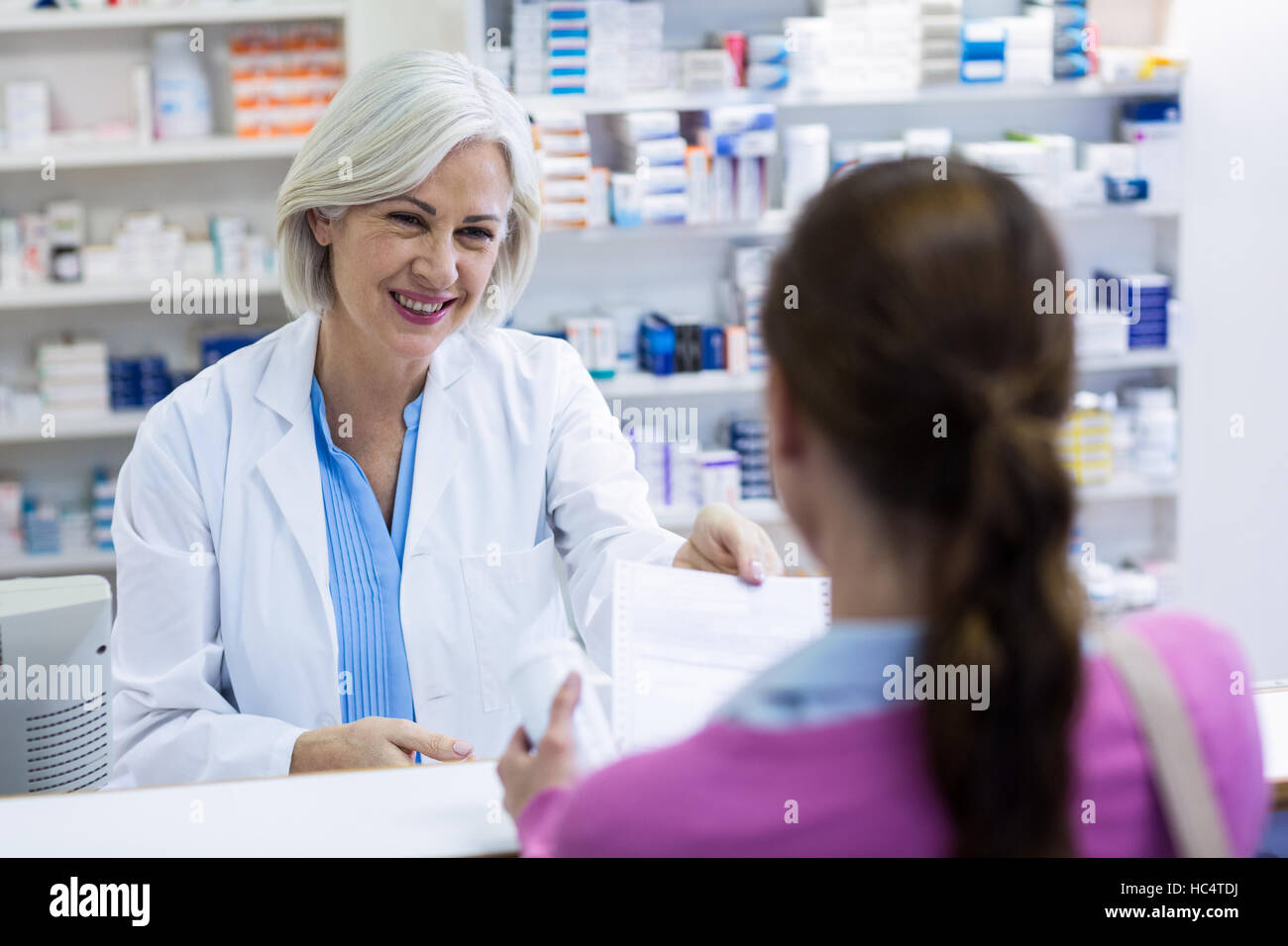 Pharmacist giving prescriptions of medicine to customer Stock Photo - Alamy