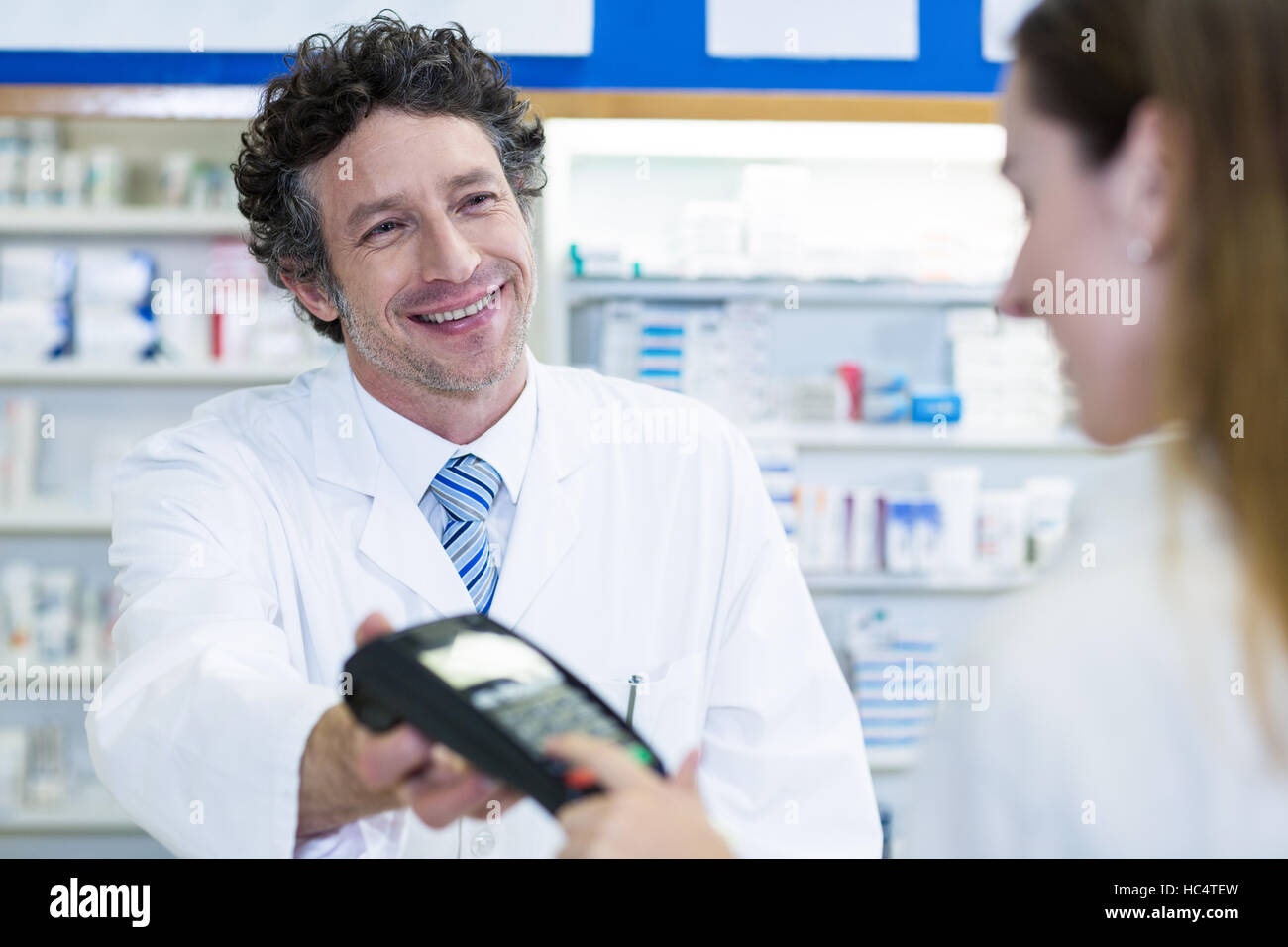Customer making payment through payment terminal Stock Photo - Alamy