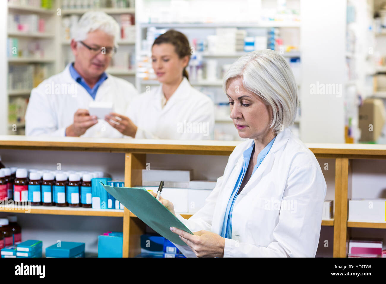 Pharmacist writing on clipboard Stock Photo - Alamy
