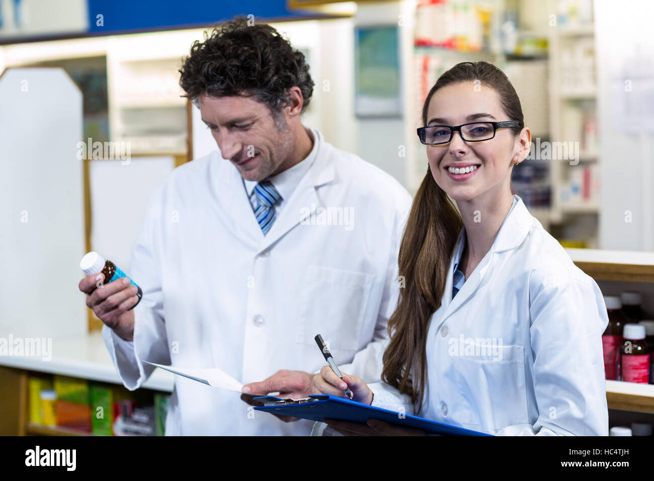 Pharmacists checking and writing prescription for medicine Stock Photo ...