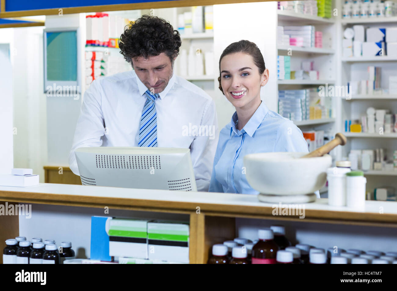 Pharmacists working at counter Stock Photo - Alamy