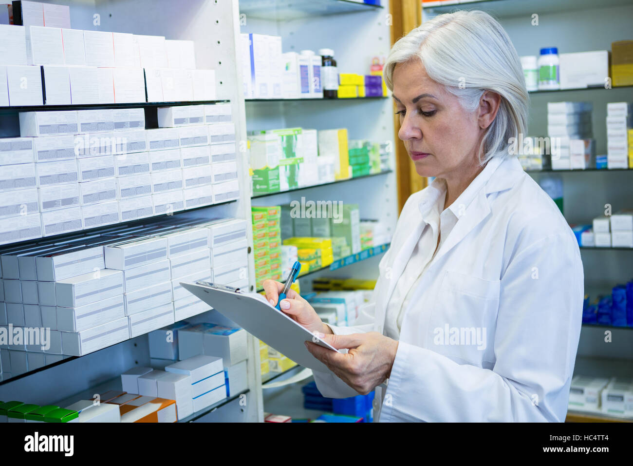 Pharmacist writing on clipboard Stock Photo - Alamy