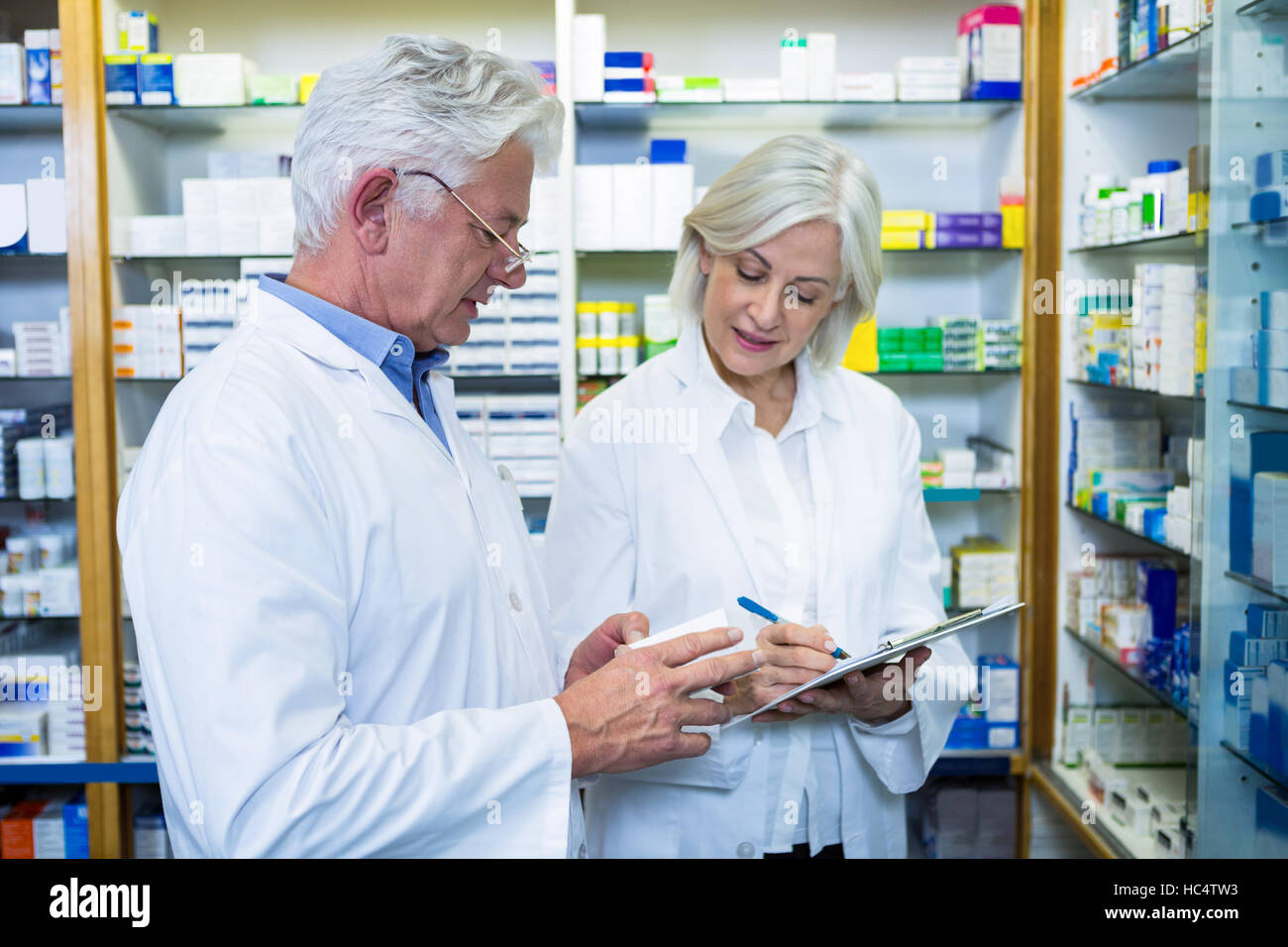 Pharmacists checking and writing prescription for medicine Stock Photo ...