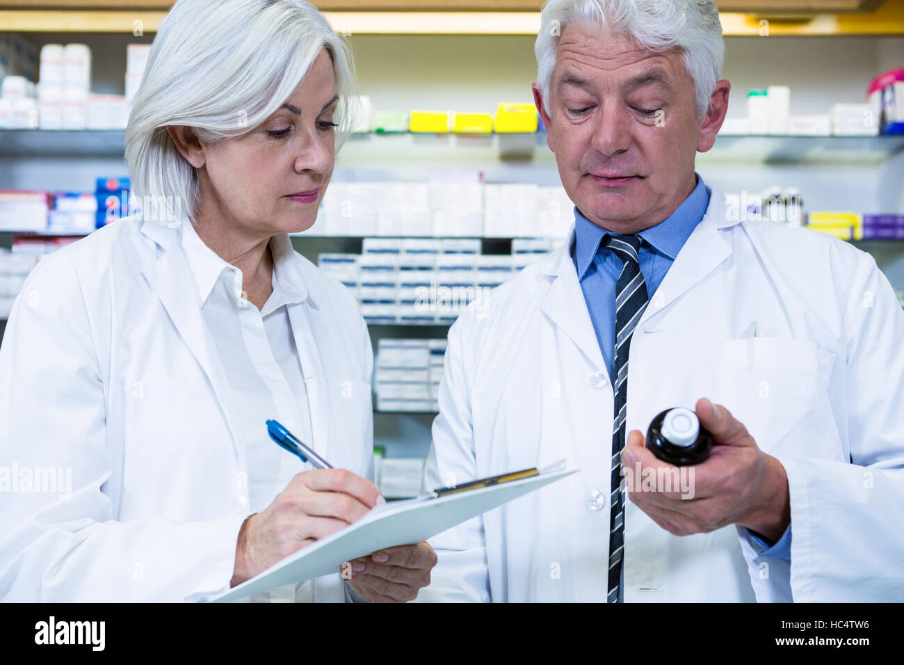 Pharmacists checking and writing prescription for medicine Stock Photo ...