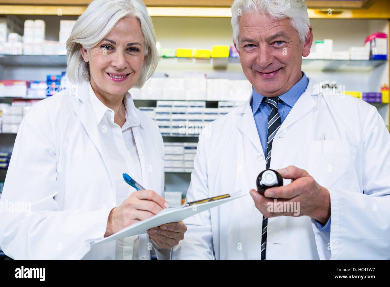 Pharmacists checking and writing prescription for medicine Stock Photo ...