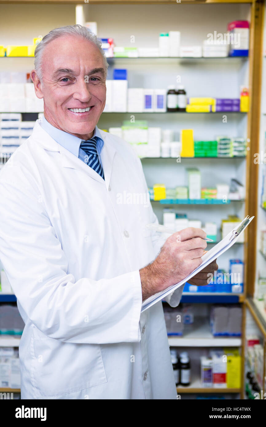 Pharmacist writing on clipboard Stock Photo - Alamy