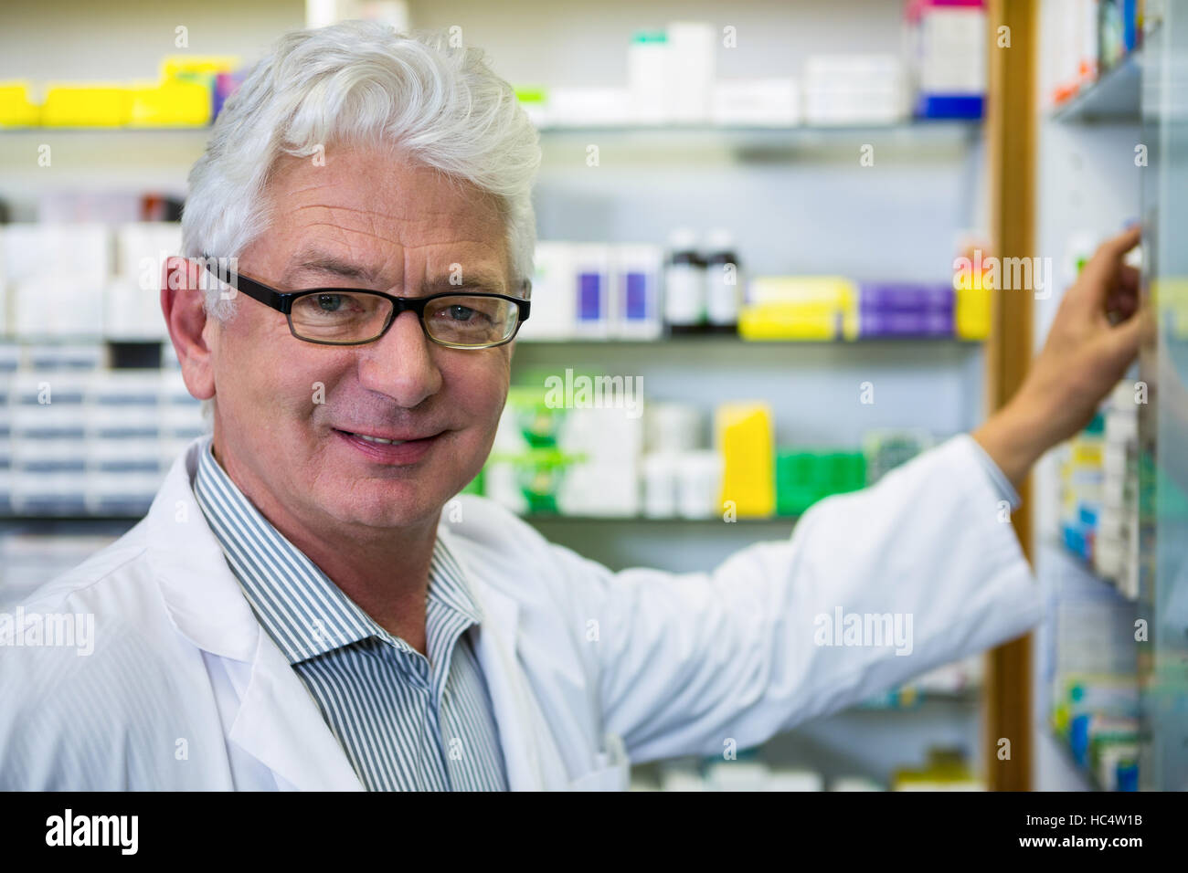 Pharmacist checking medicines in pharmacy Stock Photo - Alamy
