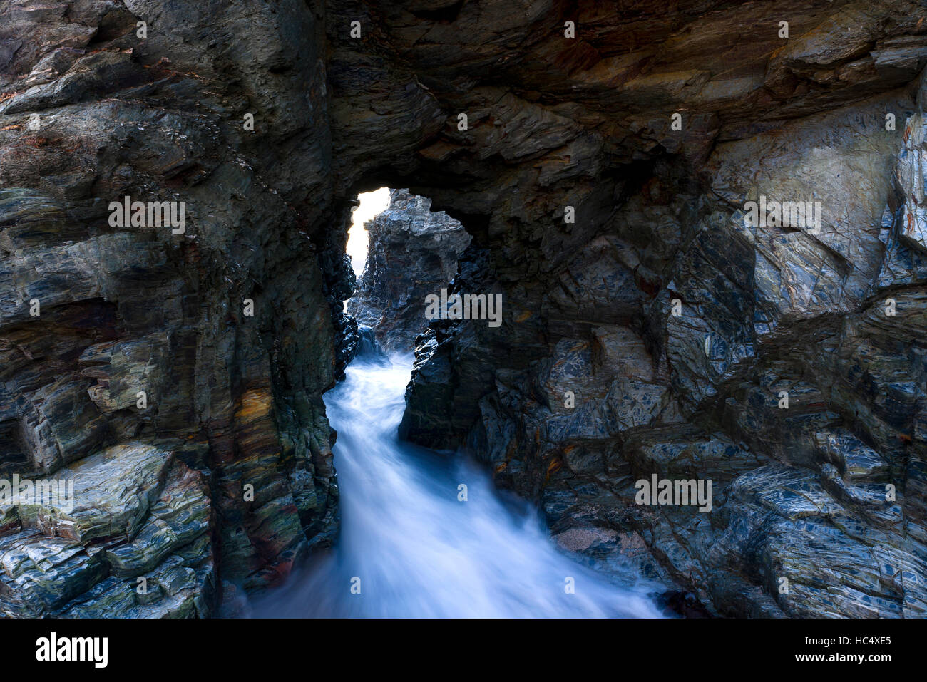 Water coming through a natural alcove at Spit Beach, St Austell ...