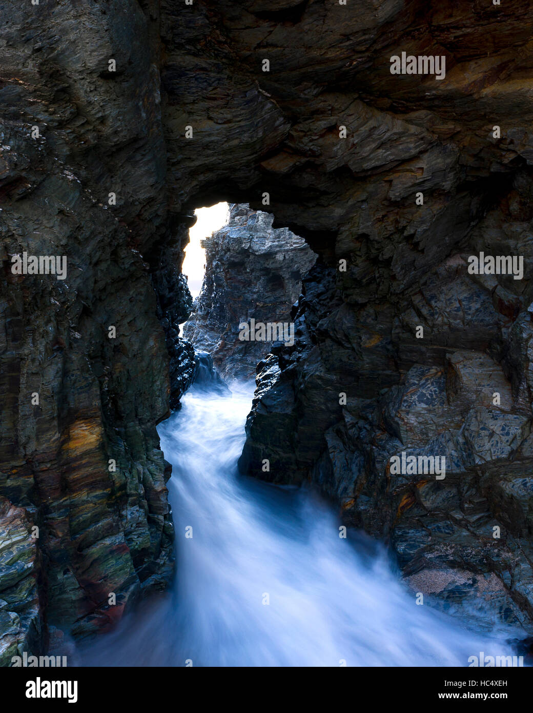 Water coming through a natural alcove at Spit Beach, St Austell ...