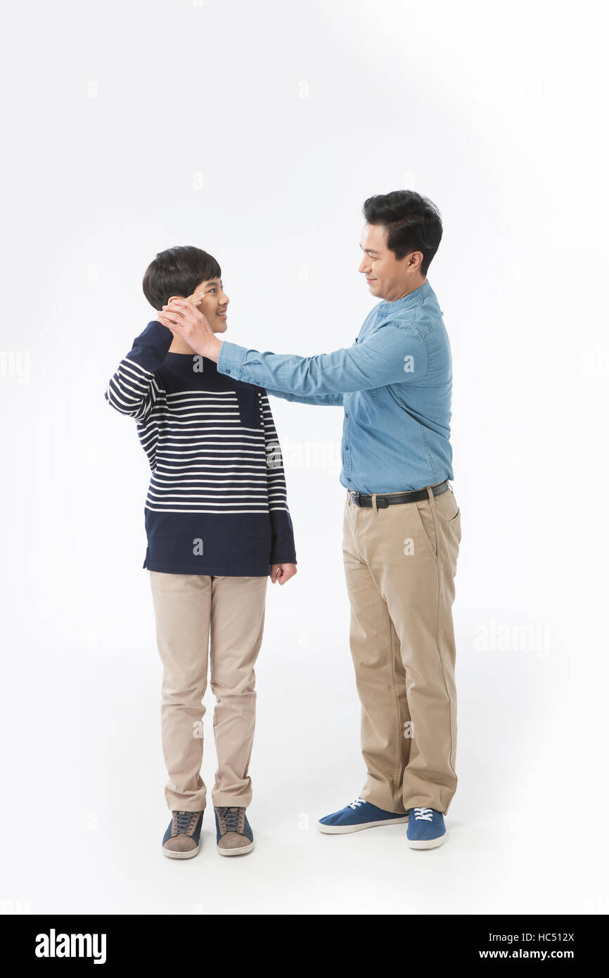 Loving middle aged father teaching his adolescent son how to salute ...