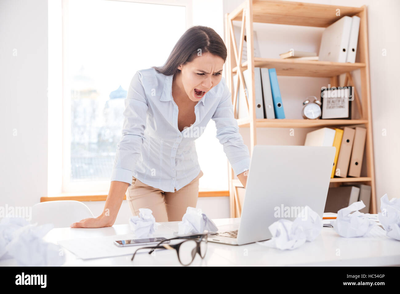 Picture of angry businesswoman dressed in white shirt sitting in her ...