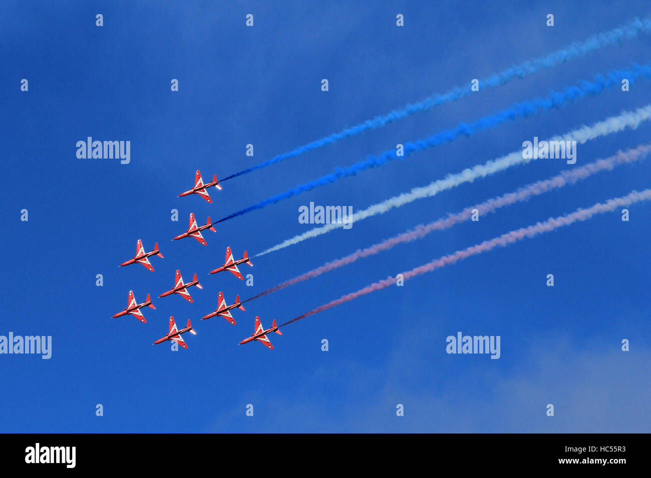 Air show red planes with trailing colour smoke Stock Photo - Alamy