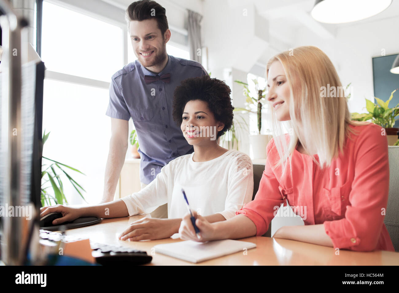 happy creative team with computer in office Stock Photo - Alamy