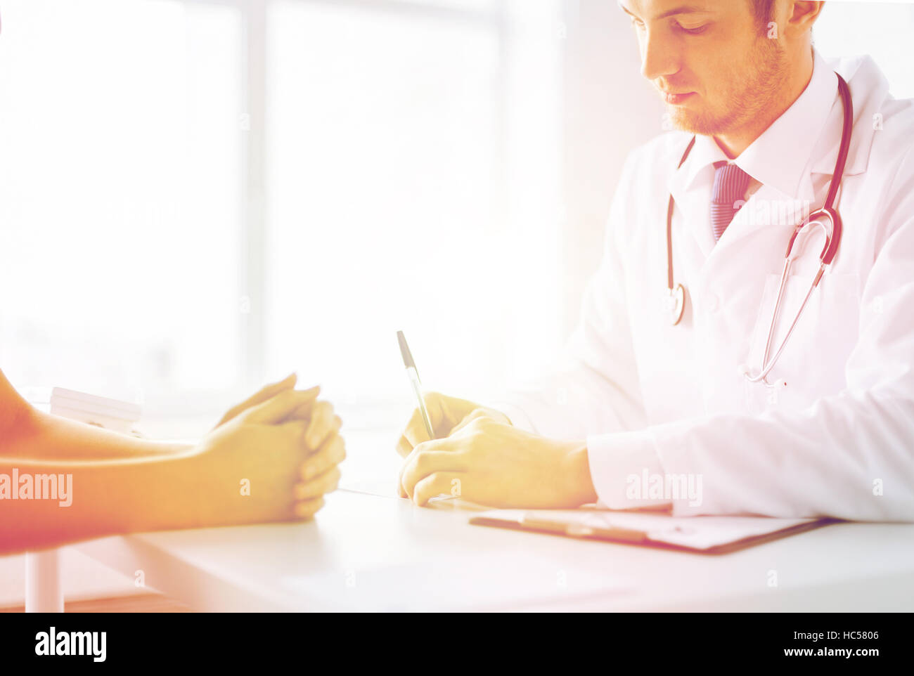 patient and doctor taking notes Stock Photo - Alamy