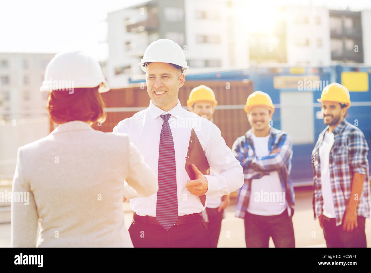 group of smiling builders in hardhats outdoors Stock Photo - Alamy
