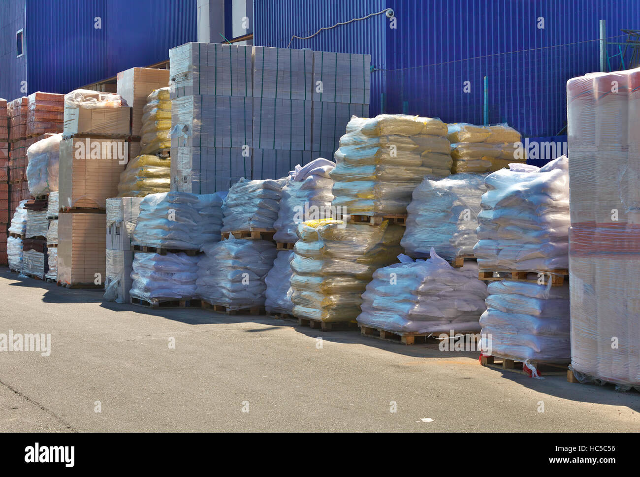 Construction materials stacked outsede near the warehouse Stock Photo ...