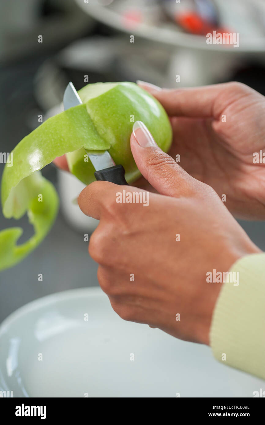 Peeling a Granny Smith apple with a peeling knife for cooking Stock ...