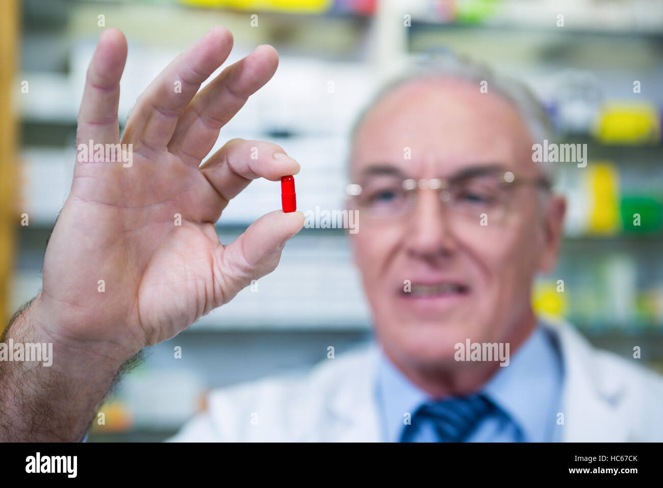 Pharmacist checking a capsule Stock Photo - Alamy