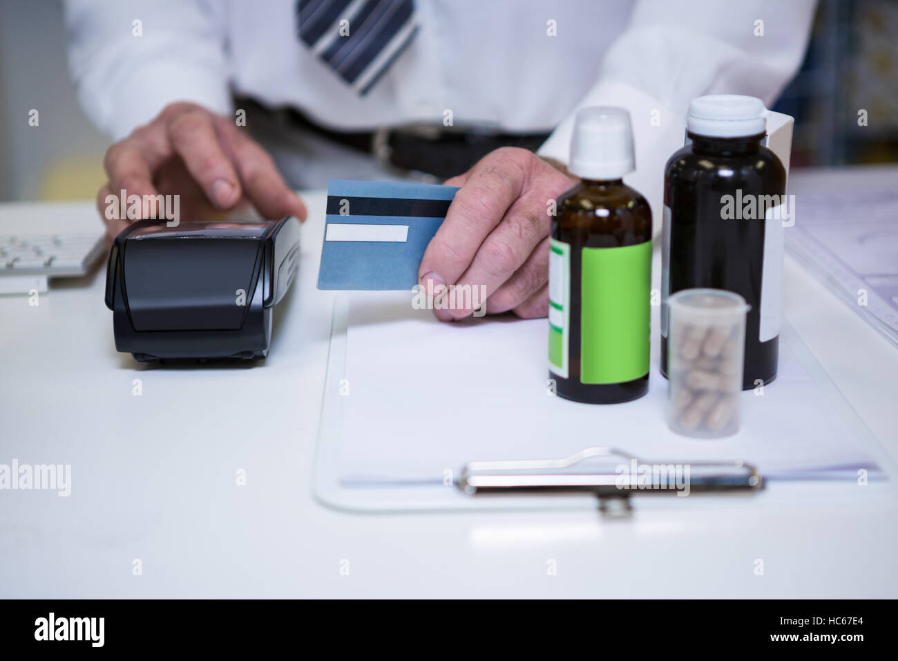 Pharmacist using payment terminal machine Stock Photo - Alamy