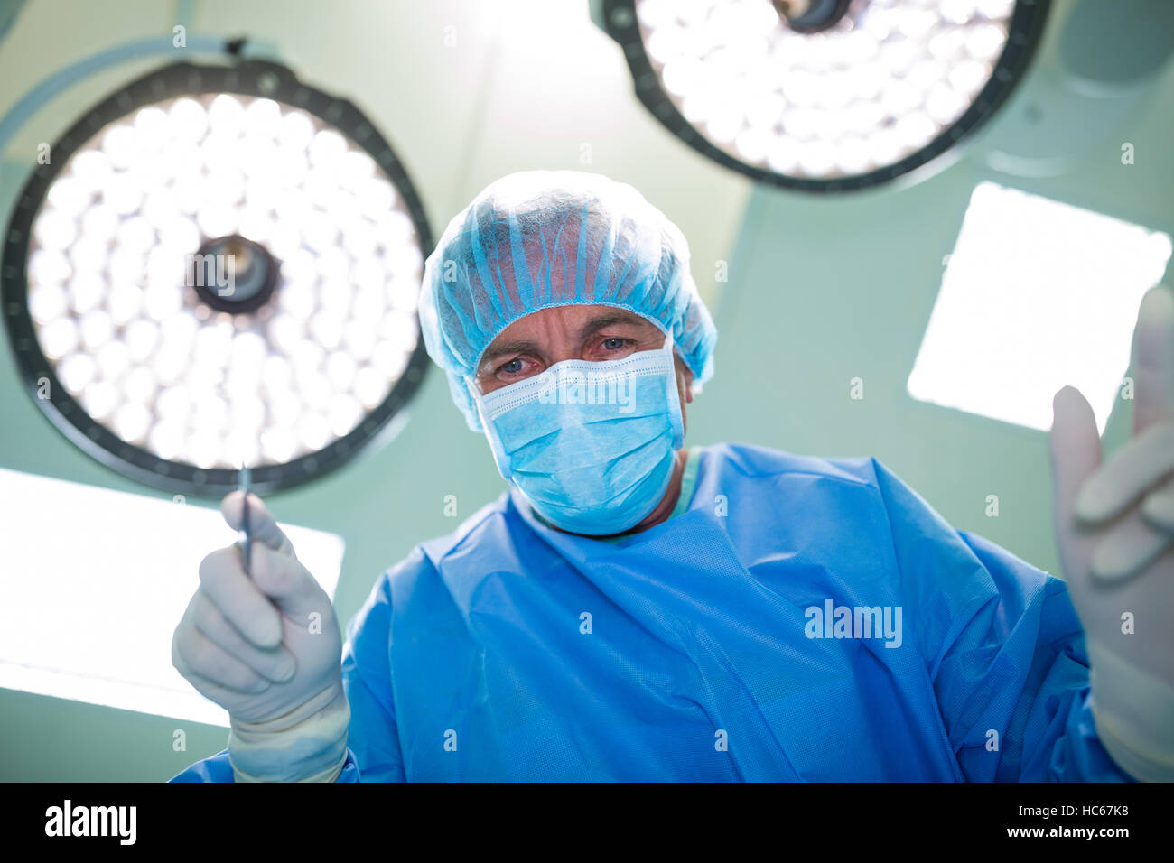 Surgeon holding surgical tool in operation room Stock Photo - Alamy