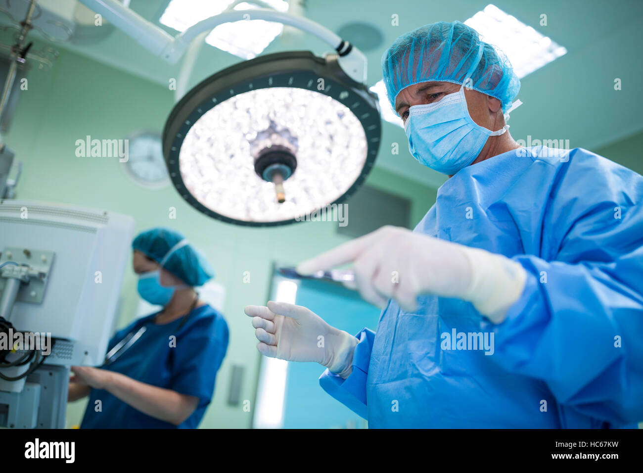 Surgeon holding surgical tool in operation room Stock Photo - Alamy