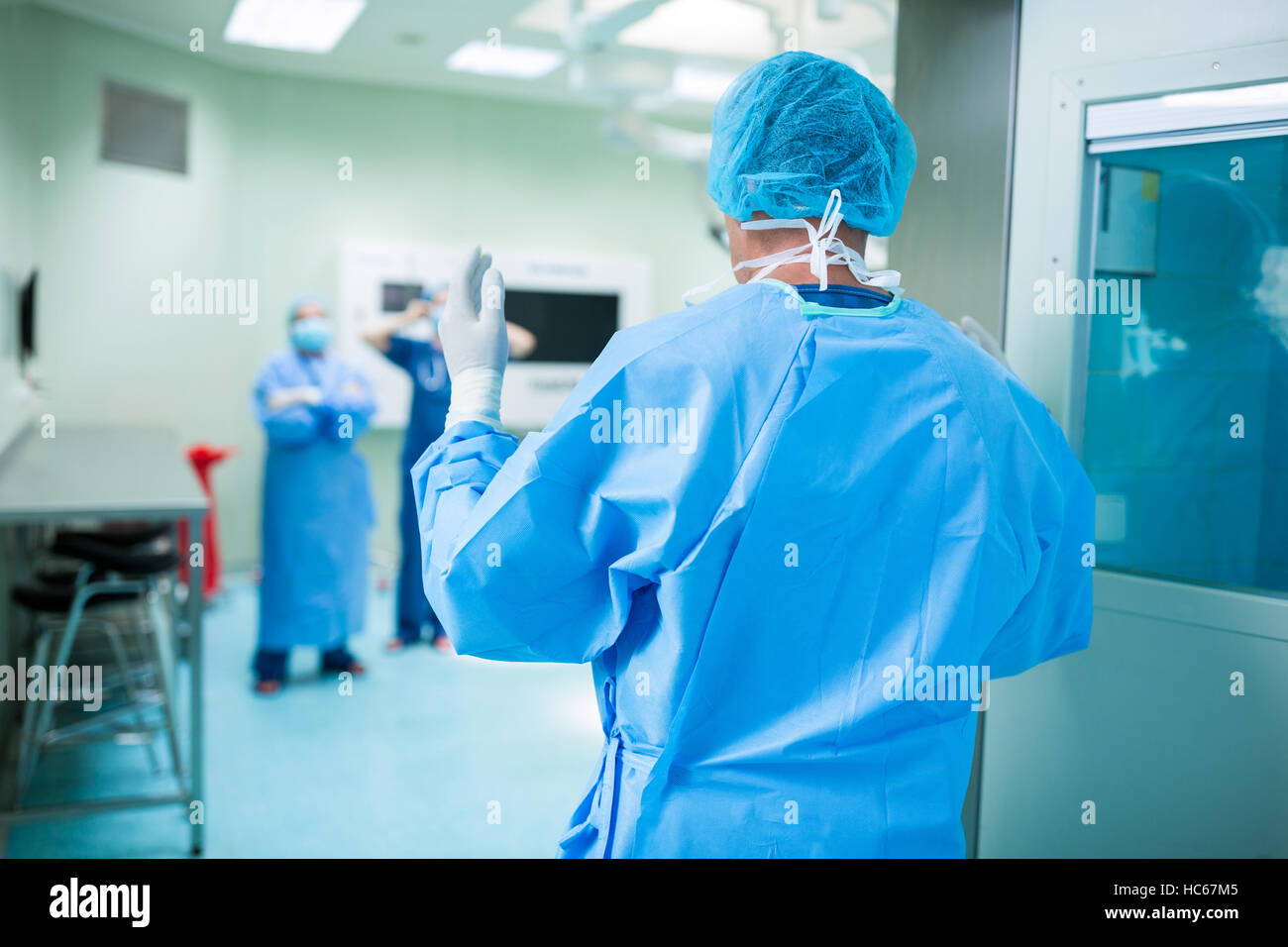 Rear view of surgeon walking in operation room Stock Photo - Alamy