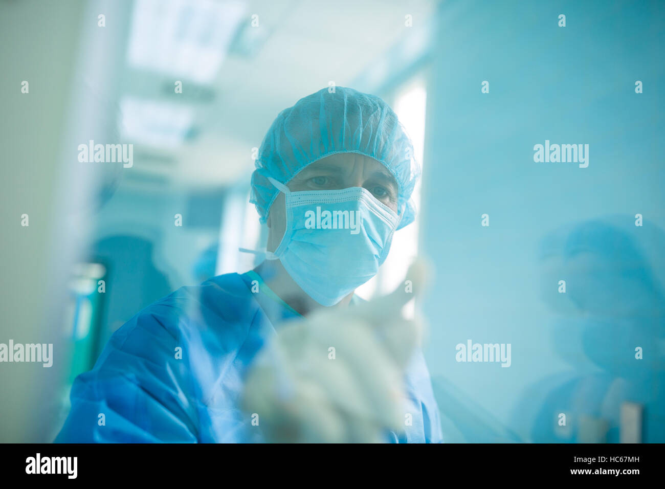 Doctor looking through a glass window Stock Photo - Alamy