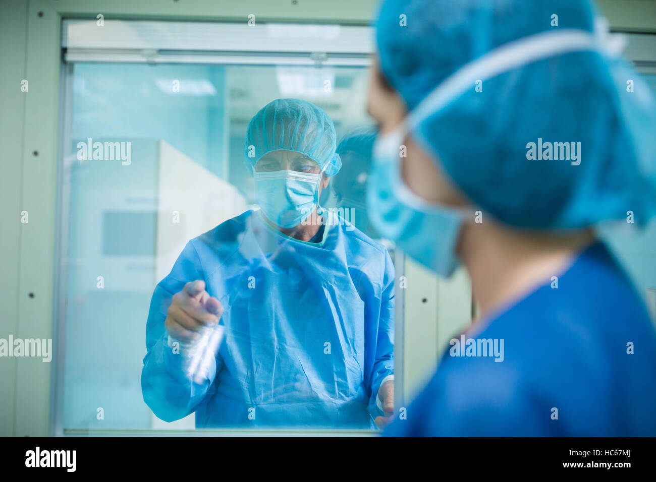 Doctor looking through a glass window Stock Photo - Alamy