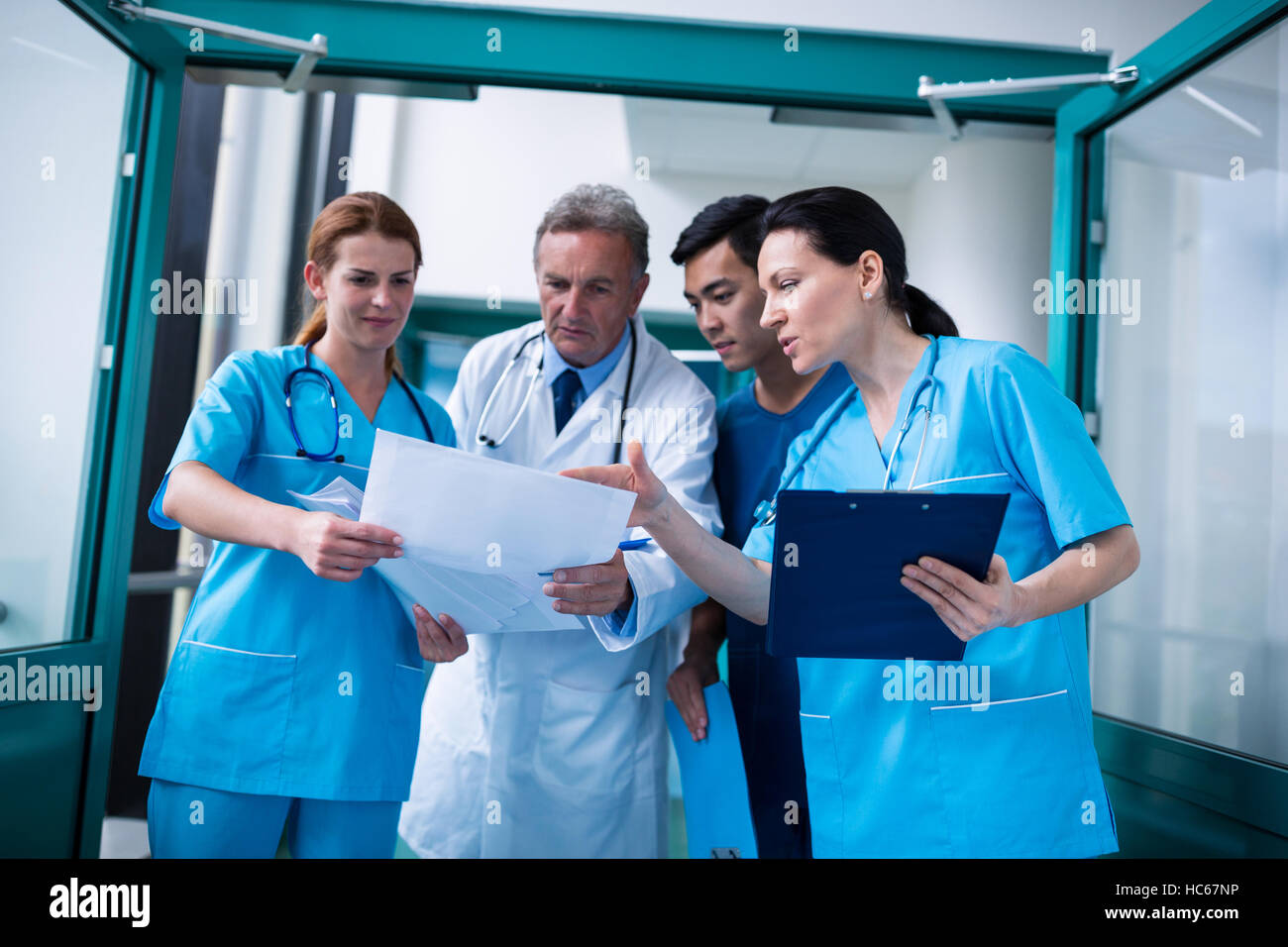 Doctor and surgeons discussing with report in surgical room Stock Photo ...