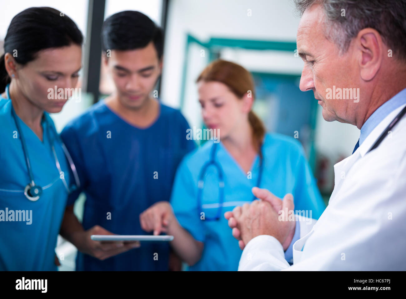 Doctor and surgeons interacting wit each other in corridor Stock Photo ...