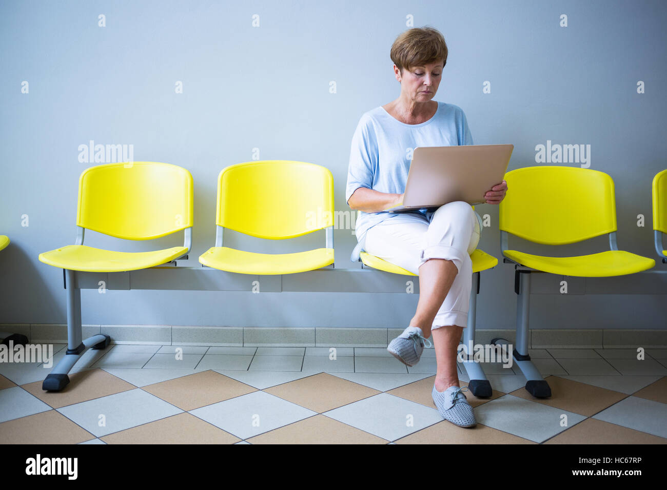 Patient sitting with report in a waiting room Stock Photo - Alamy
