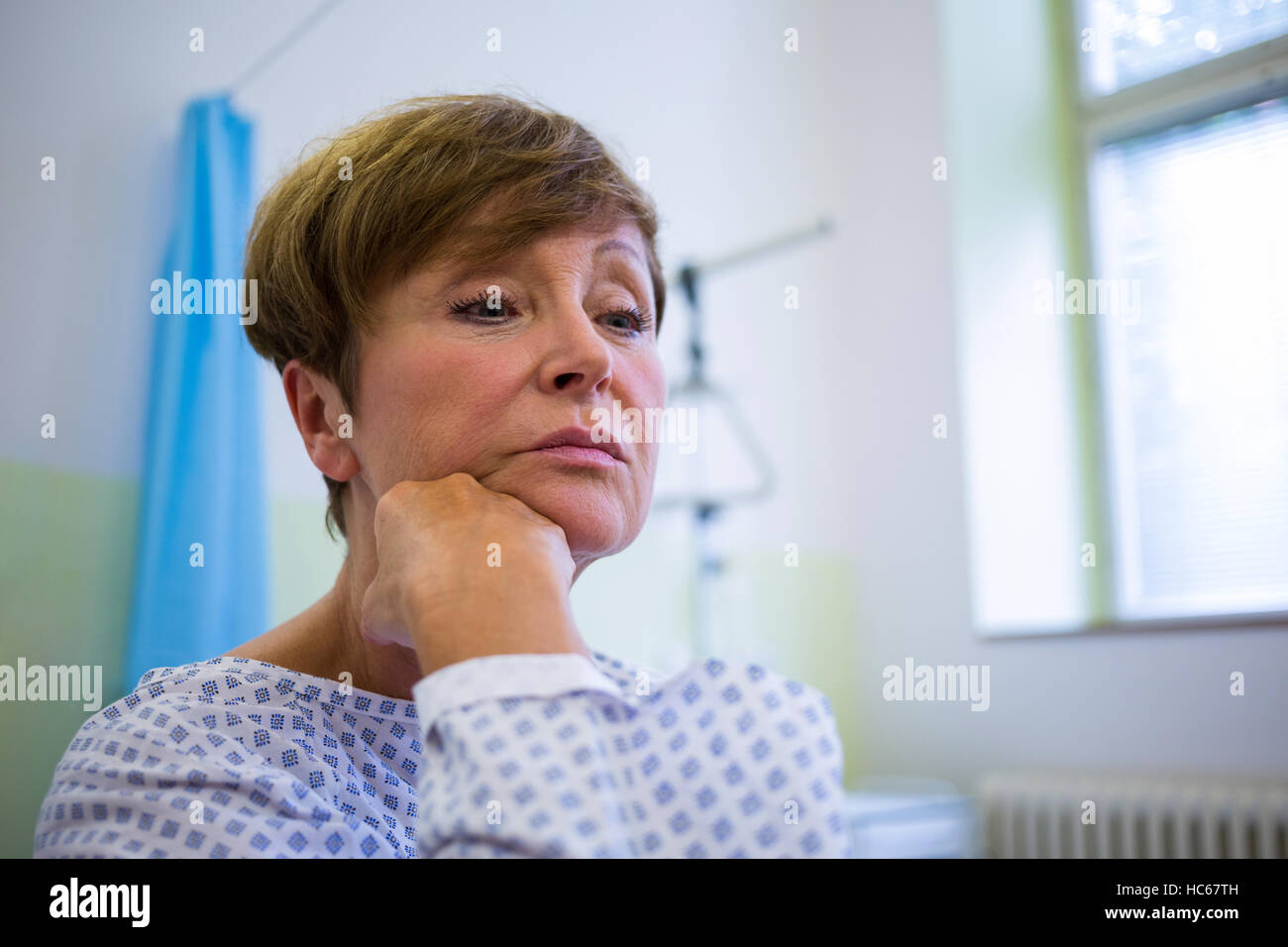 Close-up of sad senior patient sitting on a bed Stock Photo - Alamy