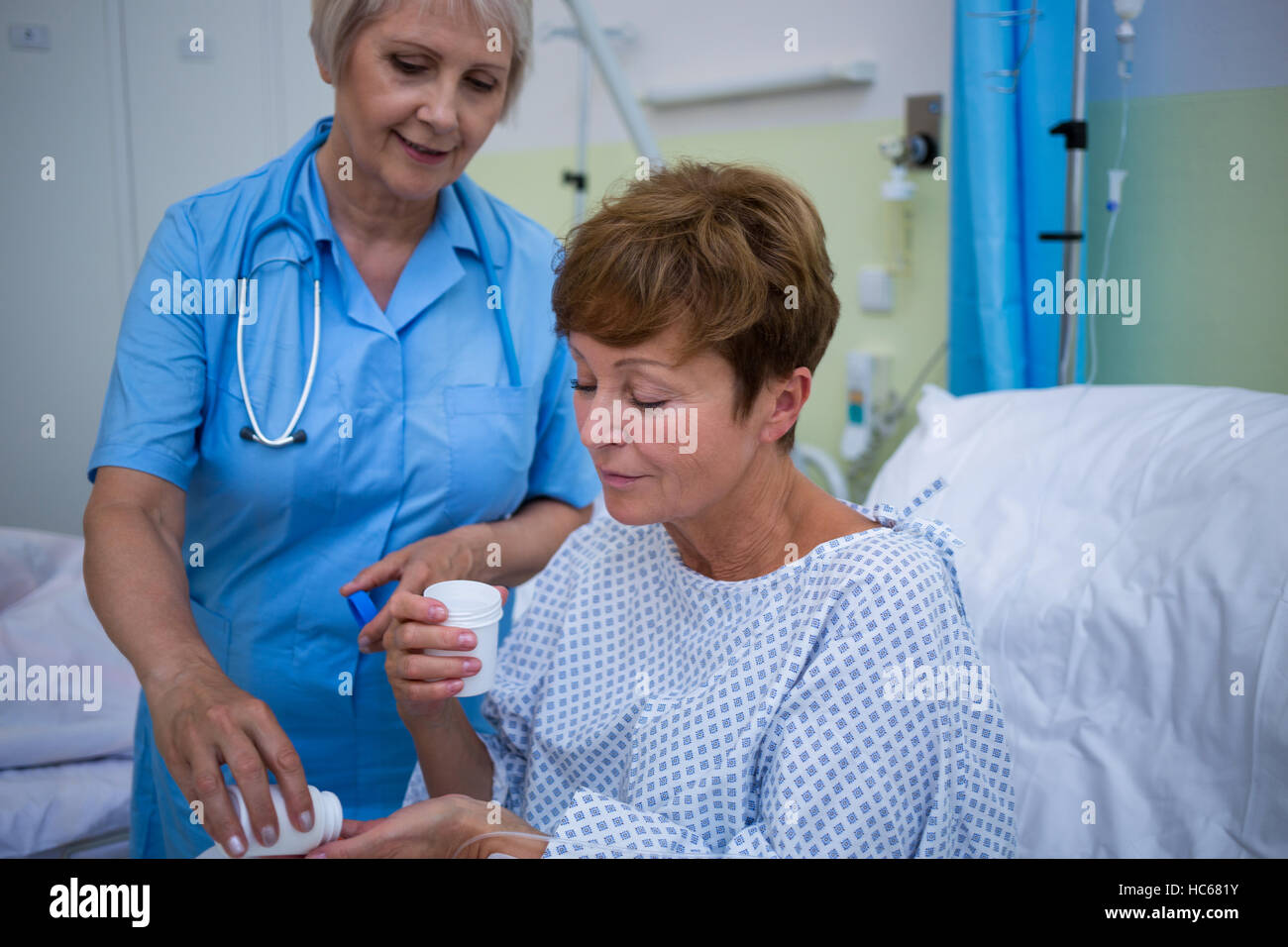 Nurse giving medication to patient Stock Photo - Alamy
