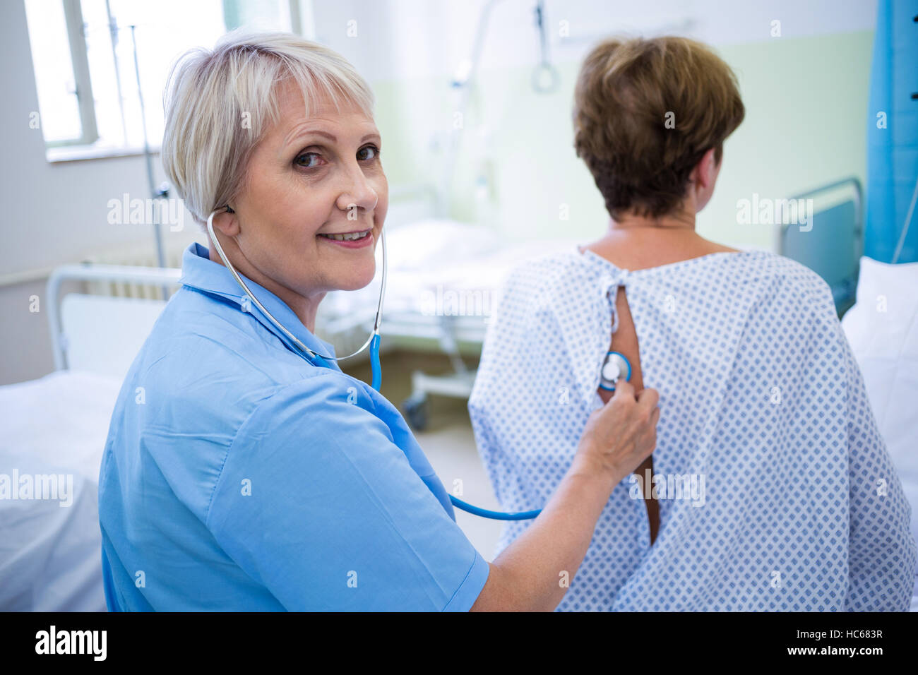 Nurse examining a patient with a stethoscope Stock Photo - Alamy