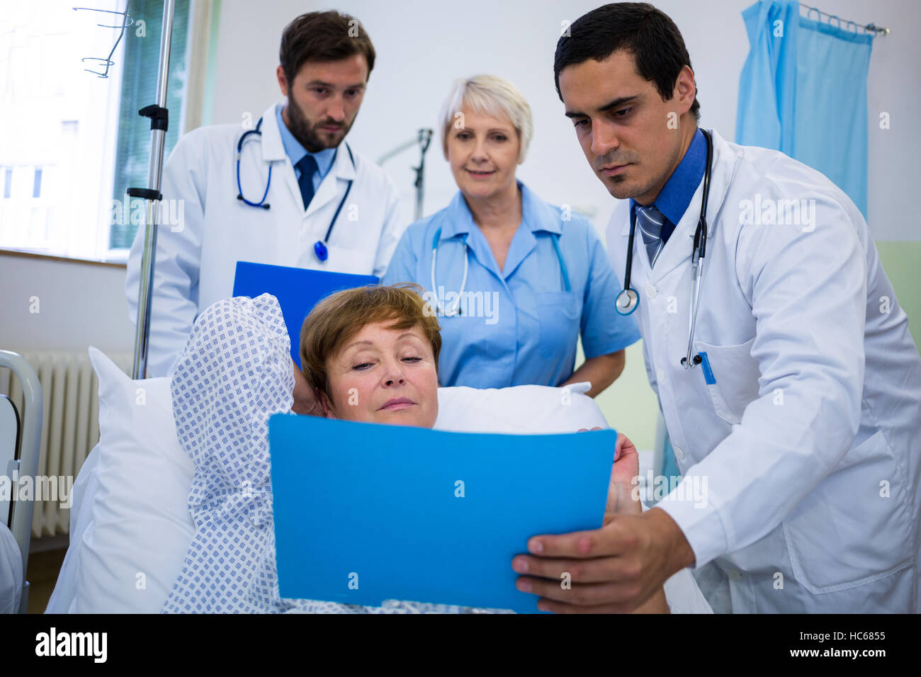 Doctors showing medical report to patient Stock Photo - Alamy