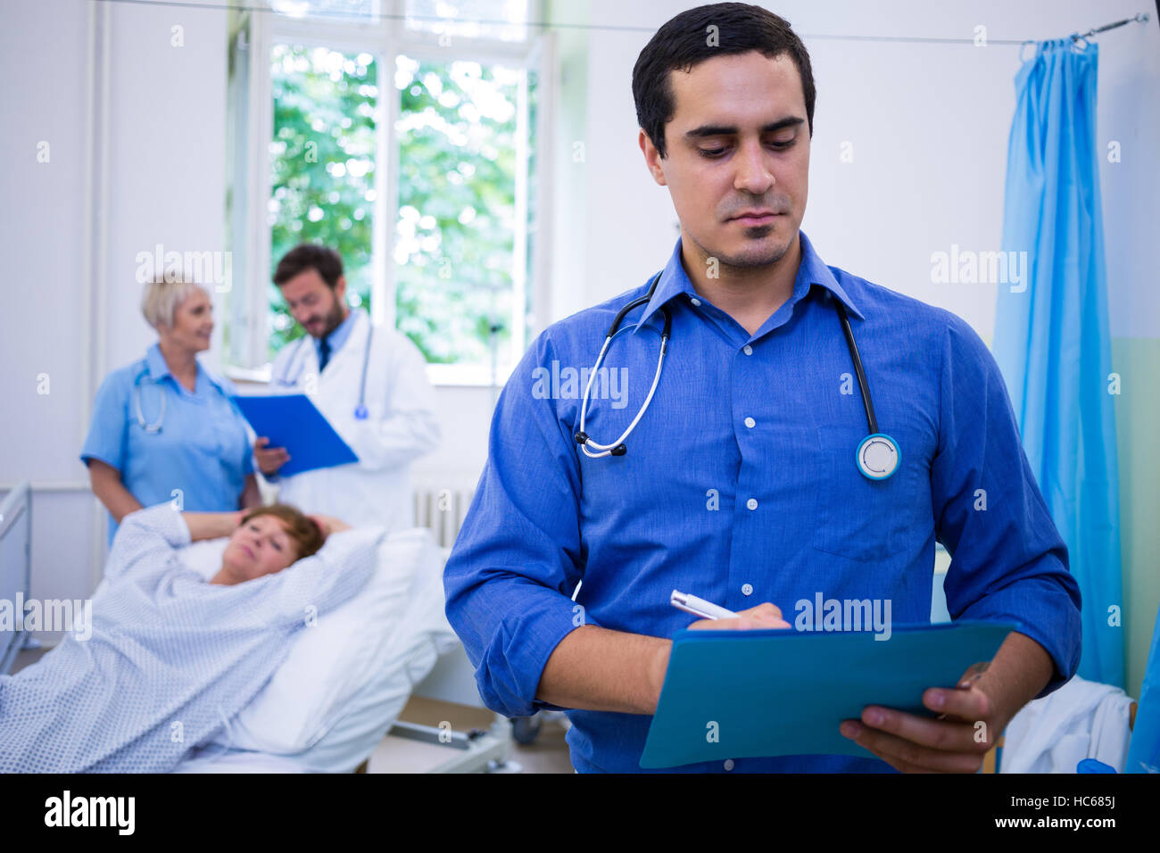 Doctor checking a medical report Stock Photo - Alamy