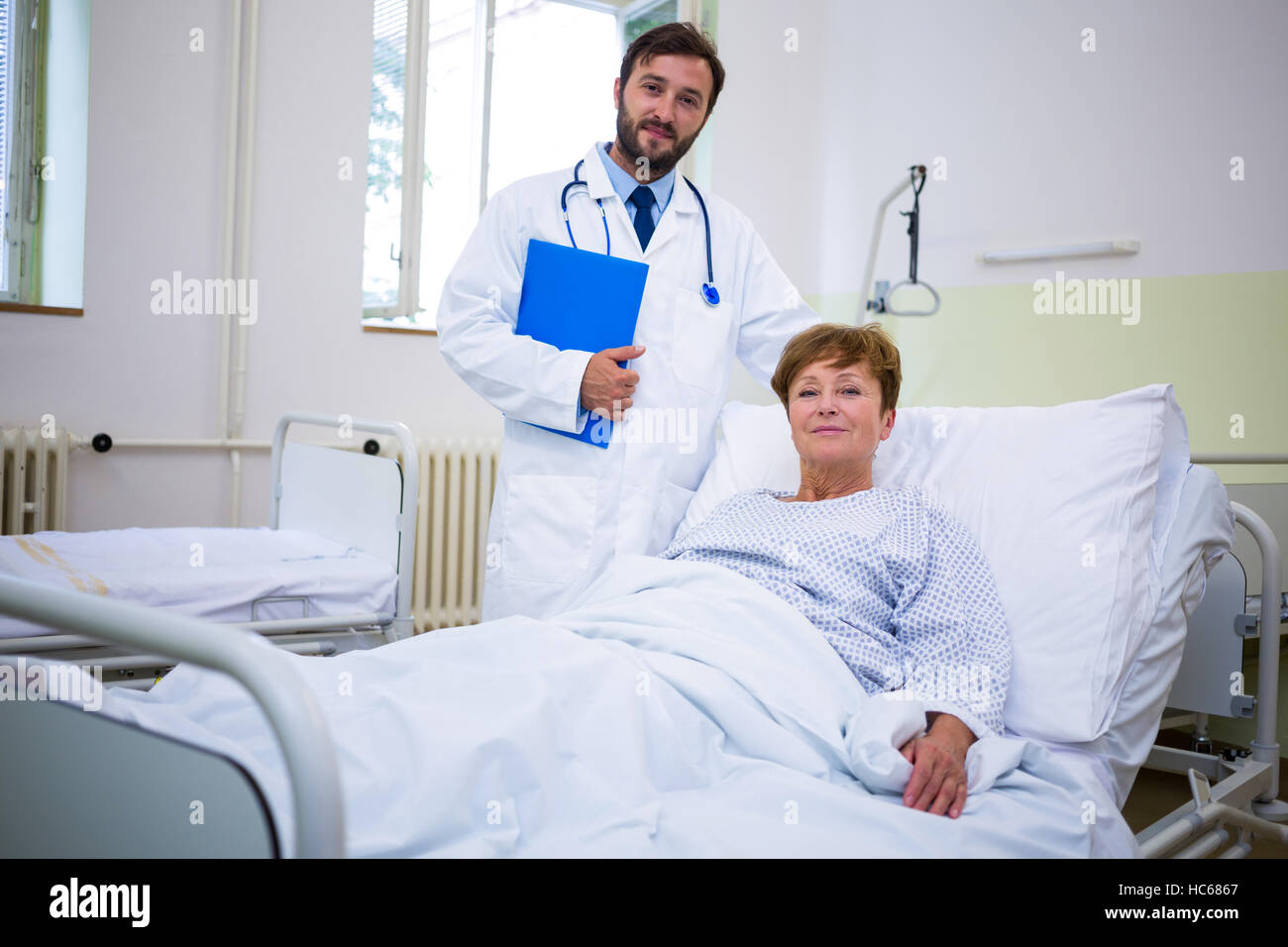 Smiling doctor and patient looking at camera in hospital Stock Photo ...
