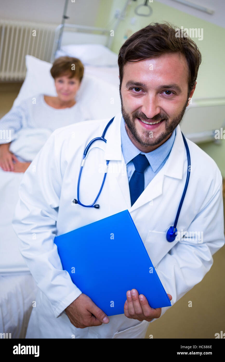Smiling doctor holding a medical report Stock Photo - Alamy