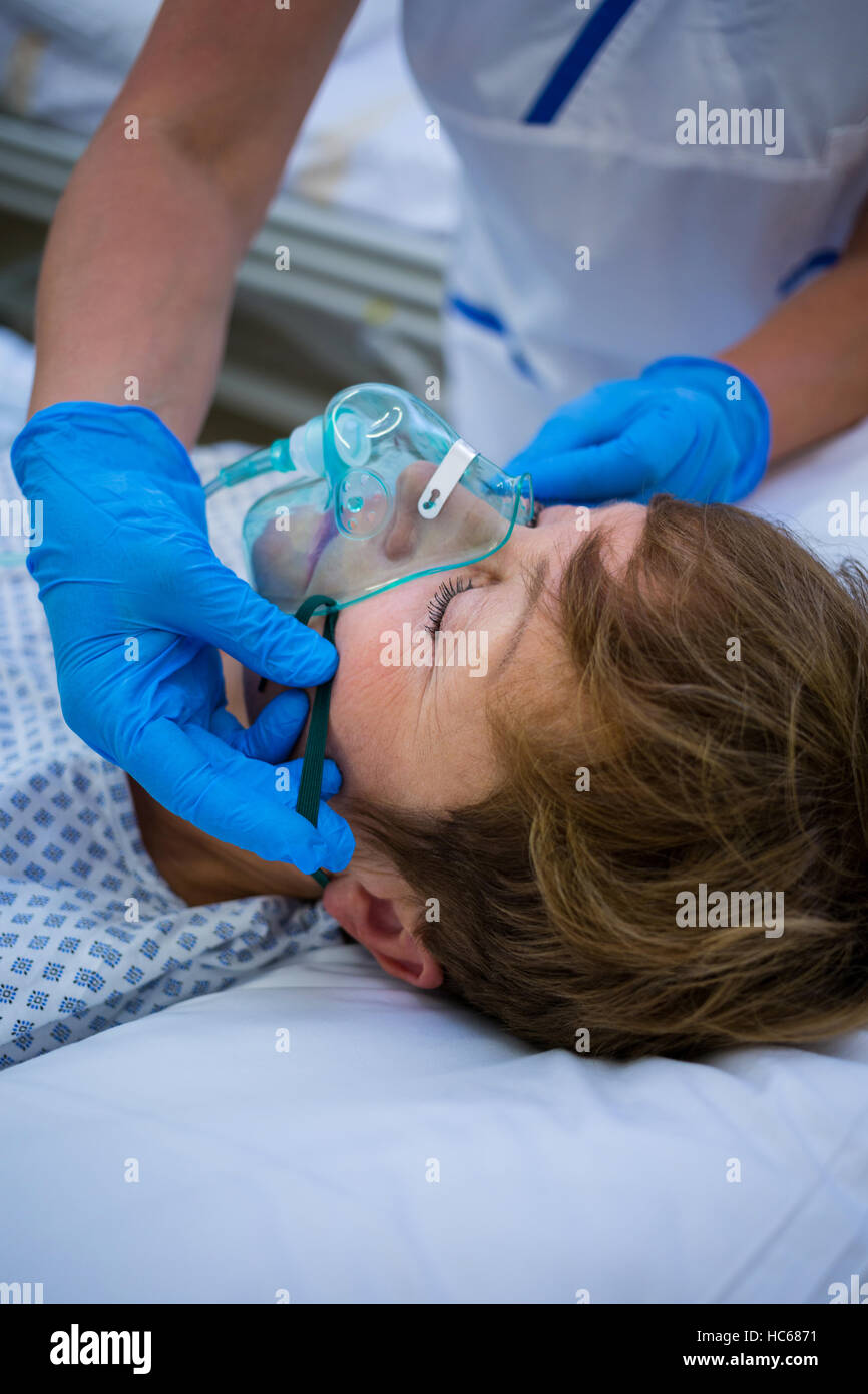 Nurse placing an oxygen mask on the face of a patient Stock Photo - Alamy