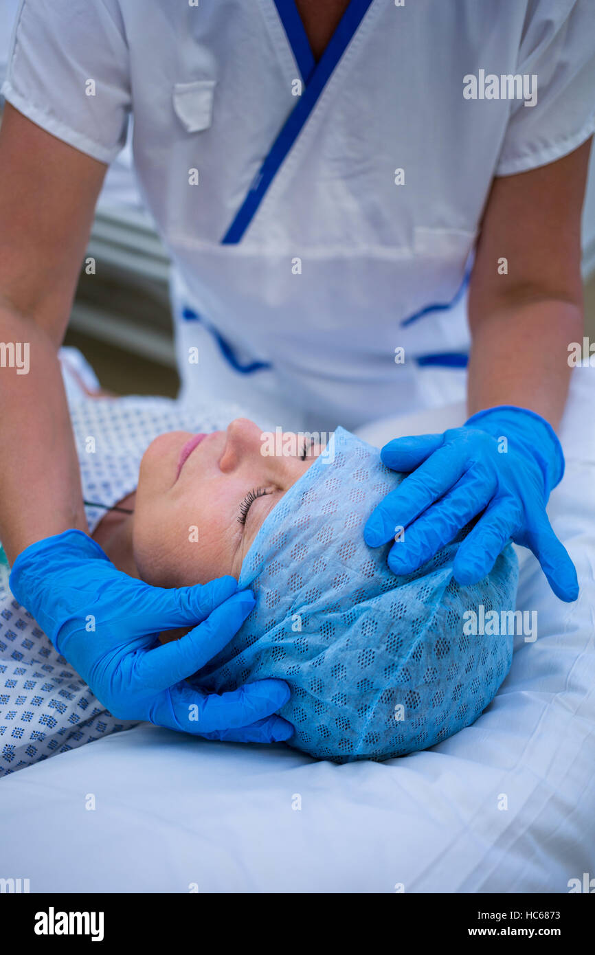 Nurse putting a surgical cap to patient Stock Photo - Alamy