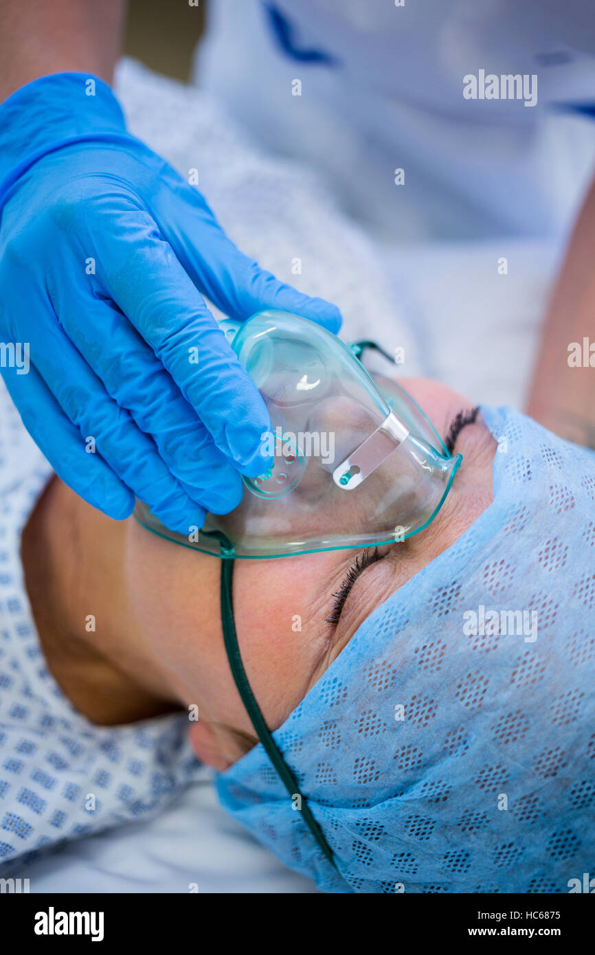 Nurse placing an oxygen mask on the face of a patient Stock Photo - Alamy