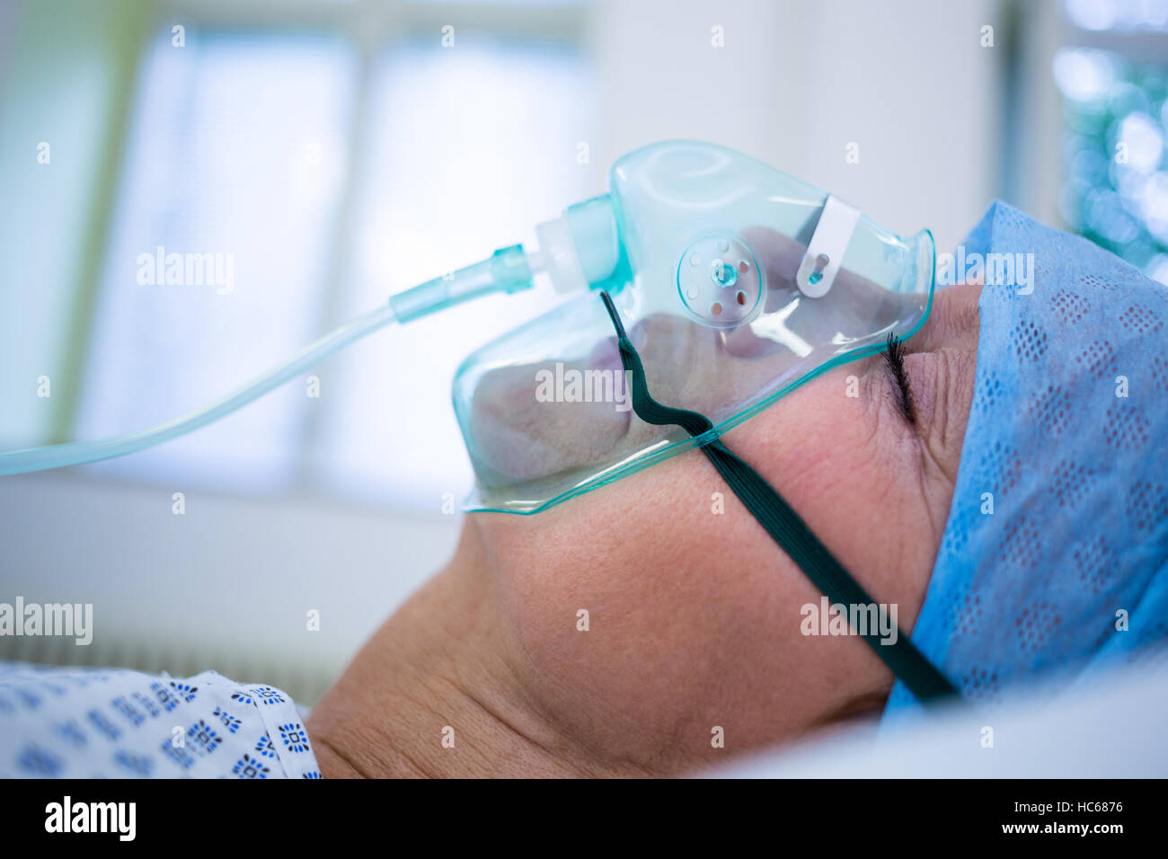 Patient wearing oxygen mask lying on hospital bed Stock Photo - Alamy