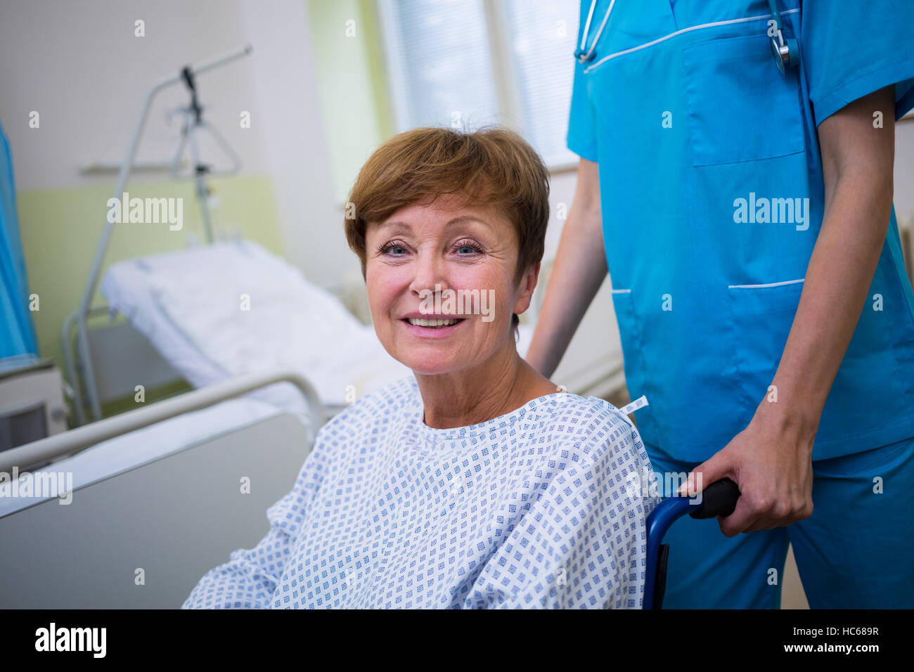 Nurse pushing disabled patient on a wheelchair Stock Photo - Alamy