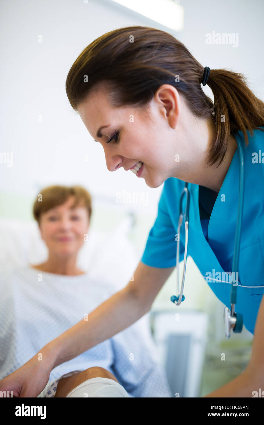 Nurse bandaging leg of patient Stock Photo - Alamy