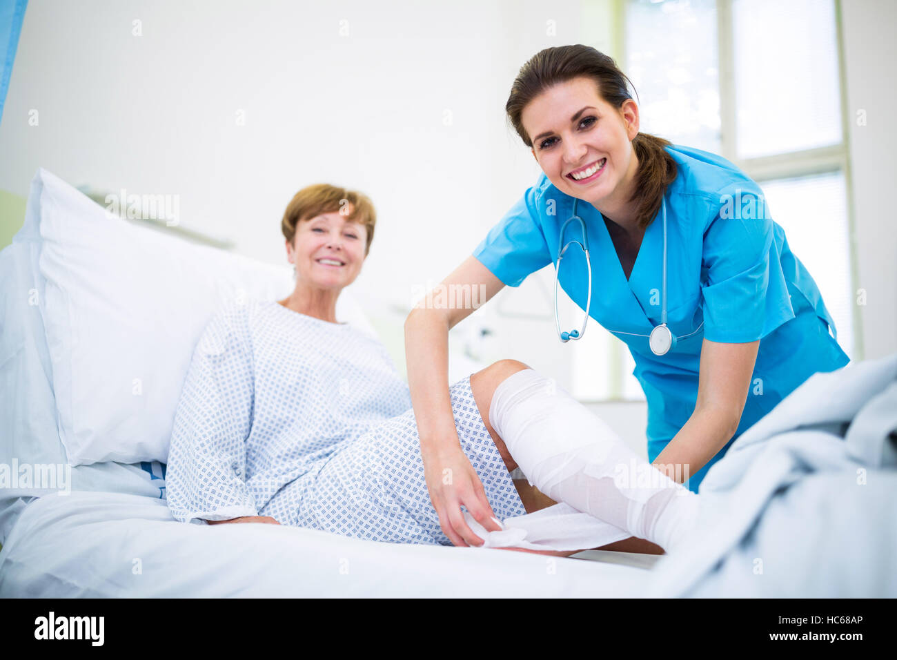 Nurse bandaging leg of patient Stock Photo - Alamy