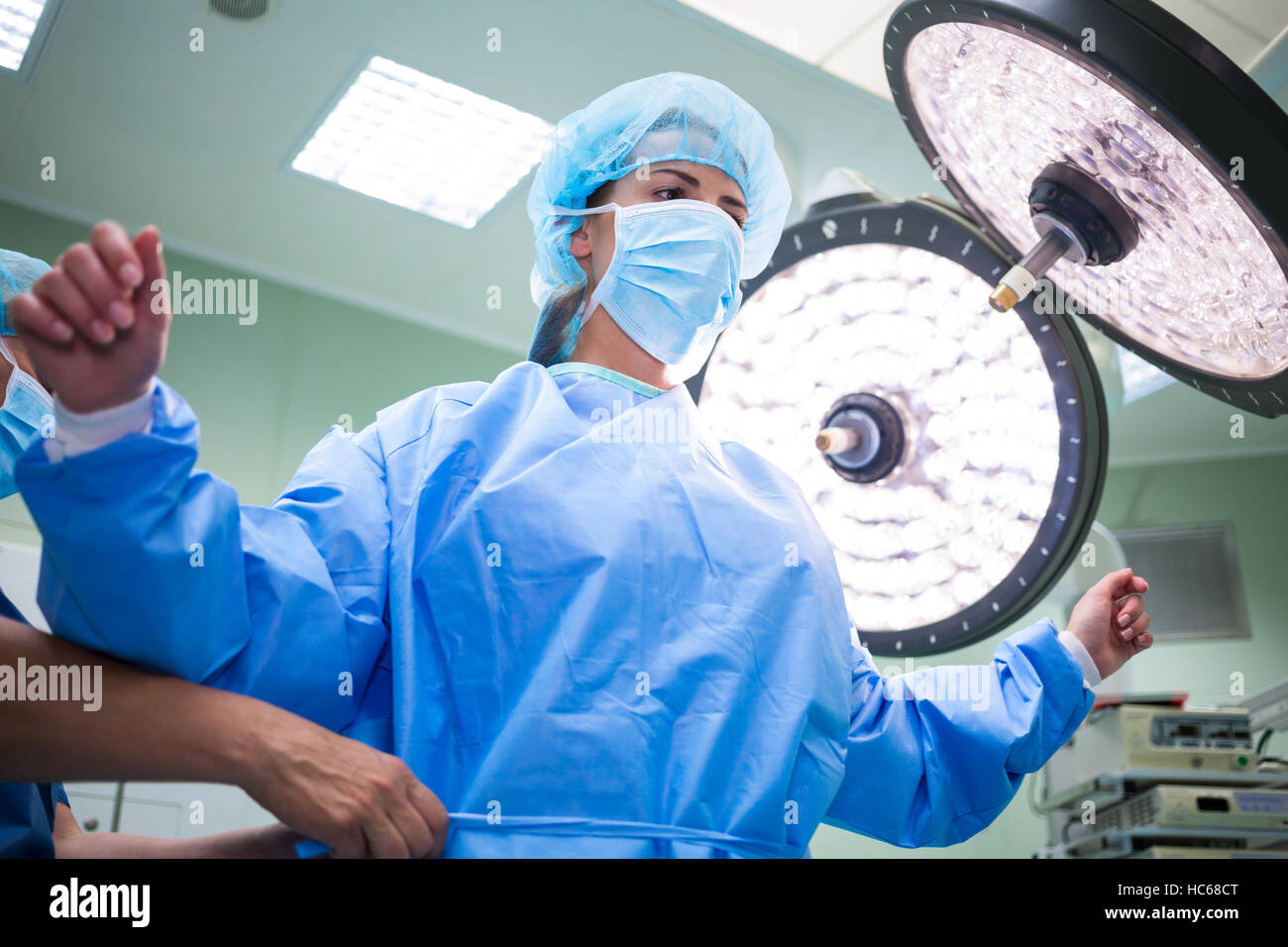 Nurse helping a surgeon in wearing scrub Stock Photo - Alamy
