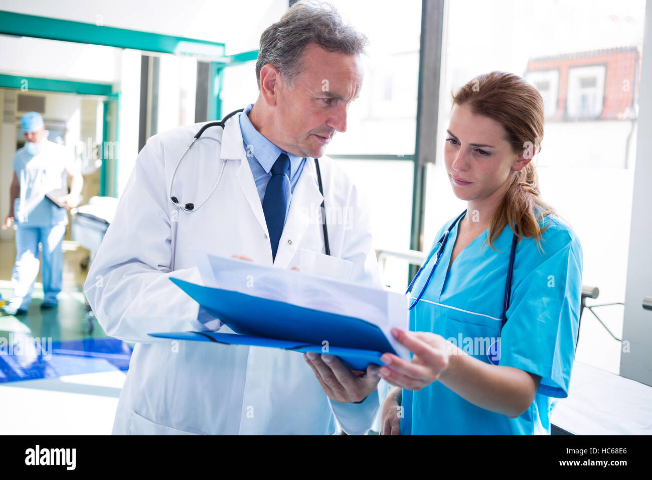 Doctor and nurse checking medical report Stock Photo - Alamy