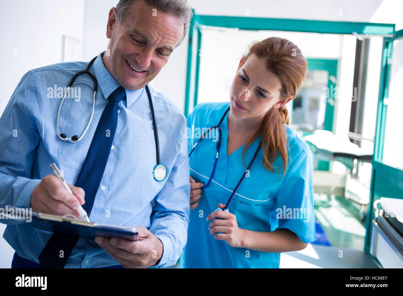 Doctor and nurse checking medical report Stock Photo - Alamy