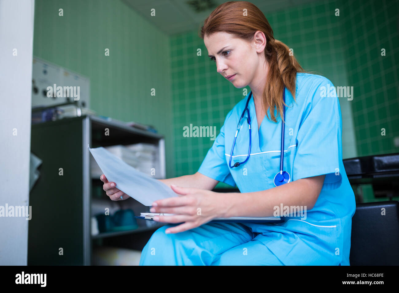 Nurse checking medical report Stock Photo - Alamy