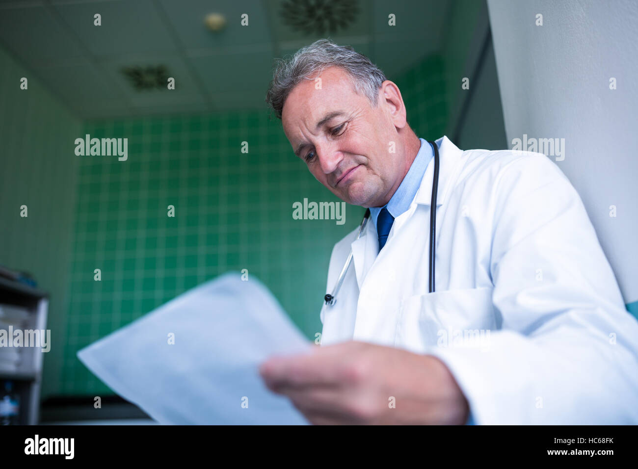 Doctor checking medical report Stock Photo - Alamy